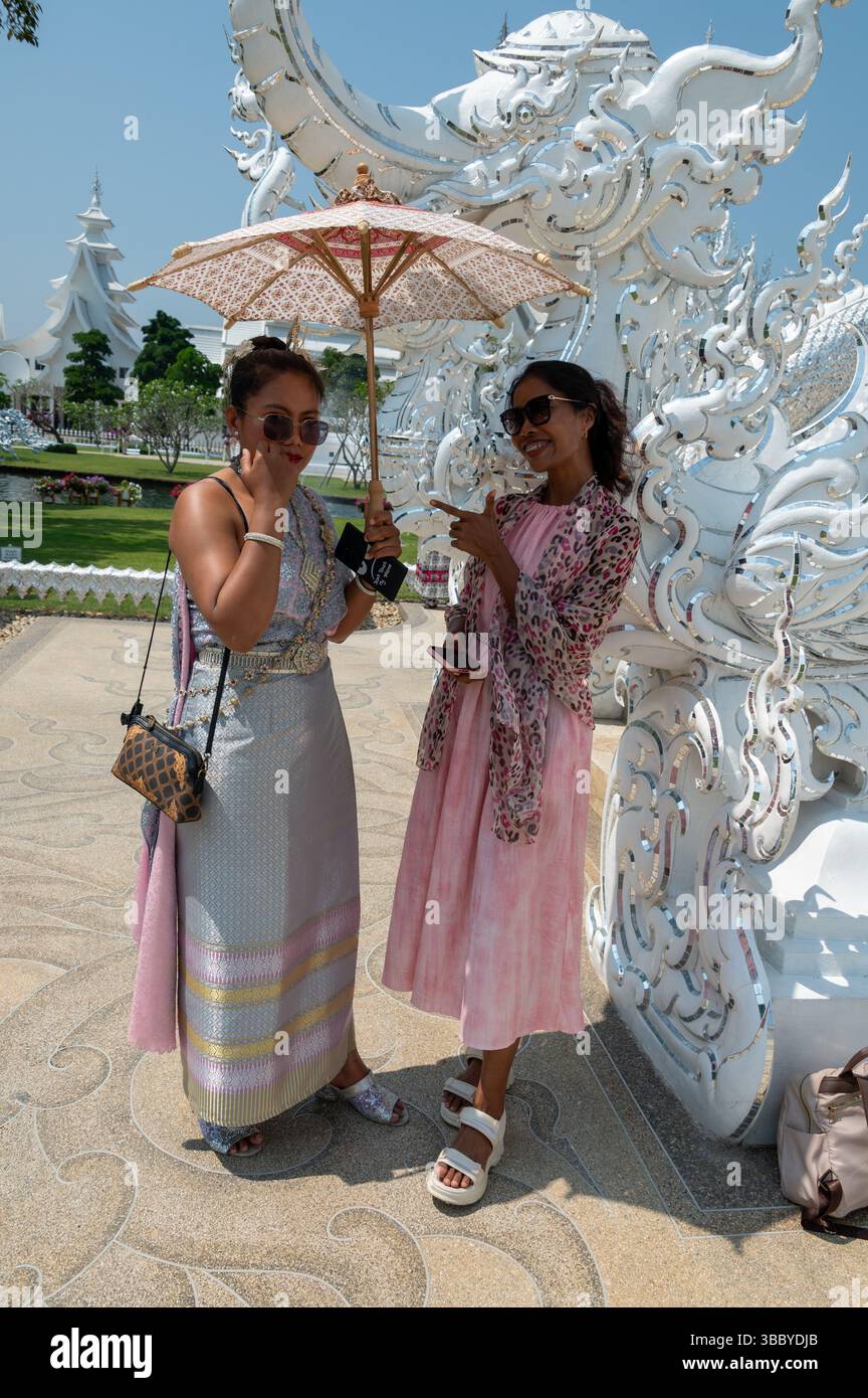 Young Thai women dressed in traditional Thai dress at the Wat Rong Khun,(White Temple). Wat Rong ...