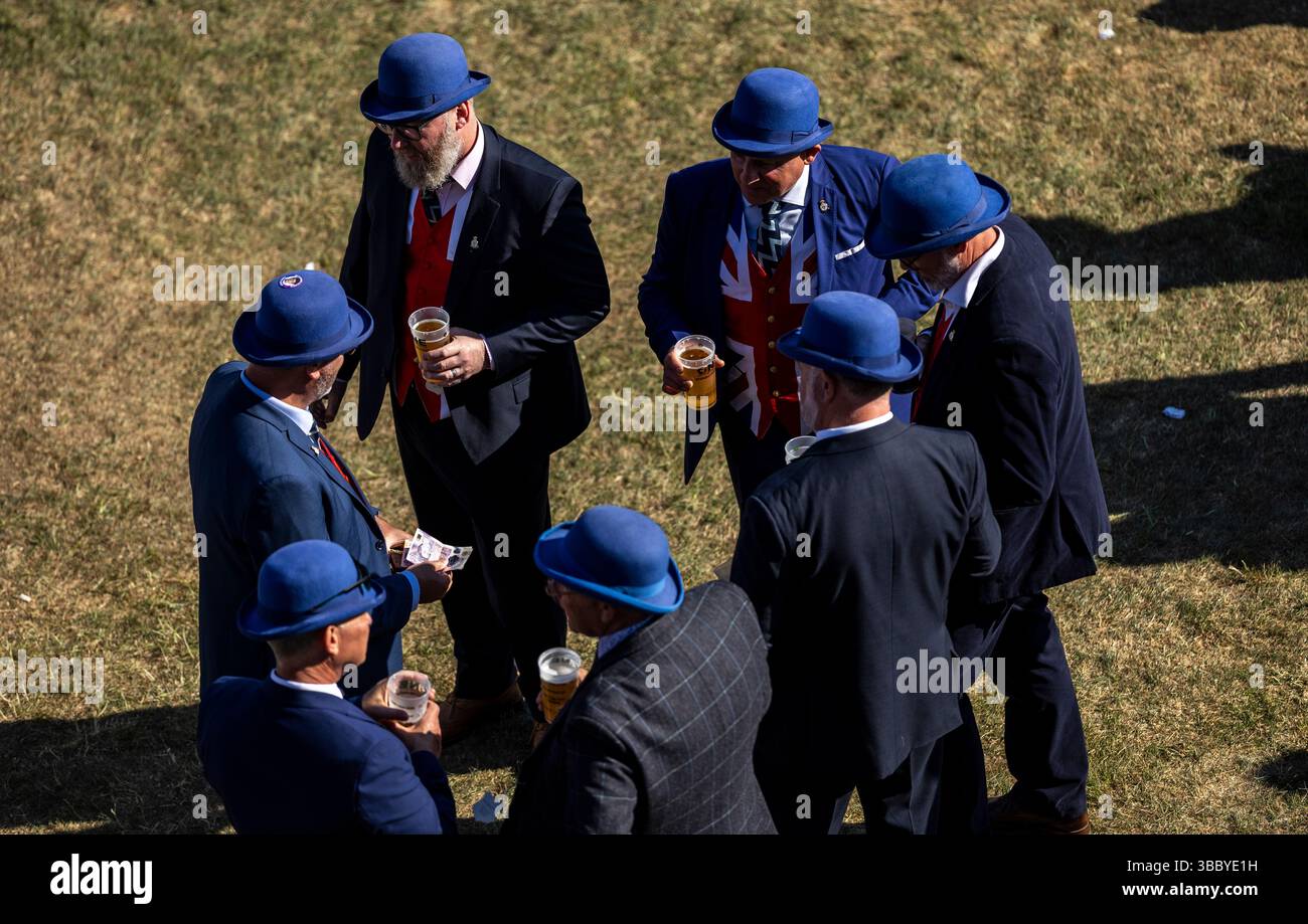 Spectators in match suit and bower hats at Newbury Racecourse. Picture ...