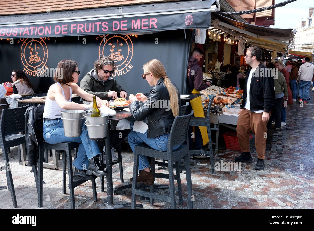 Visitors eating fish market restaurants in Trouville in Normandy ...
