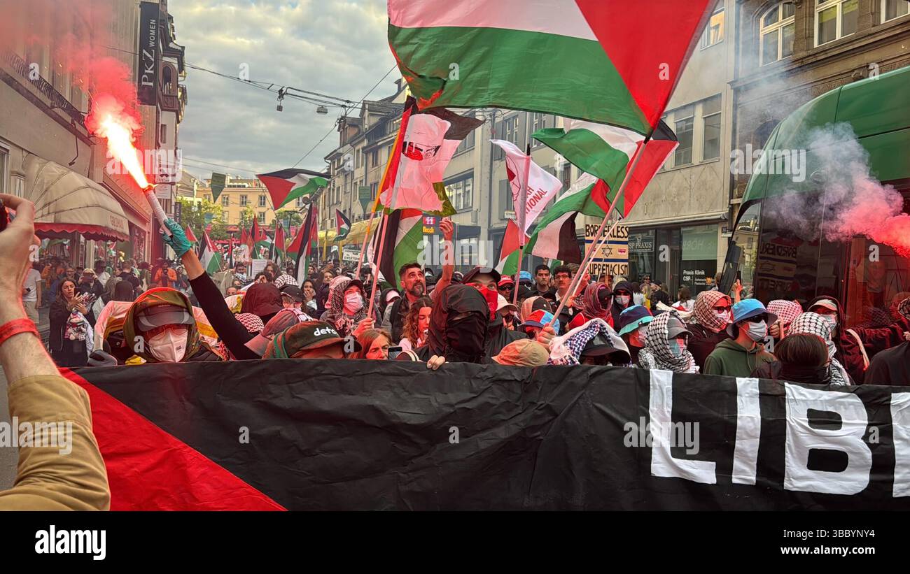 Basel, Switzerland. 17th May, 2025. People hold banners and flags ...