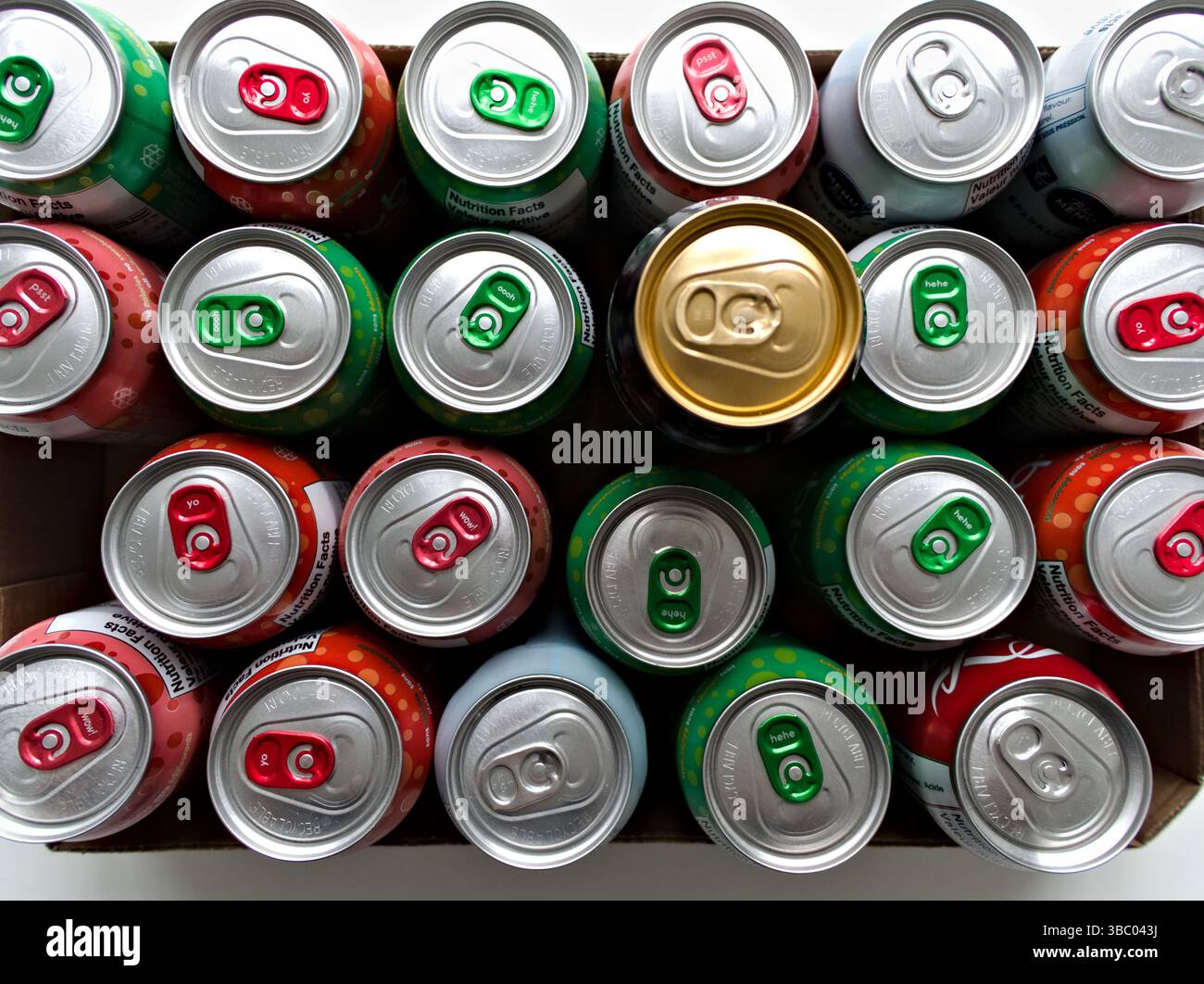 A box of soda cans with a single can that is gold. The other cans are ...