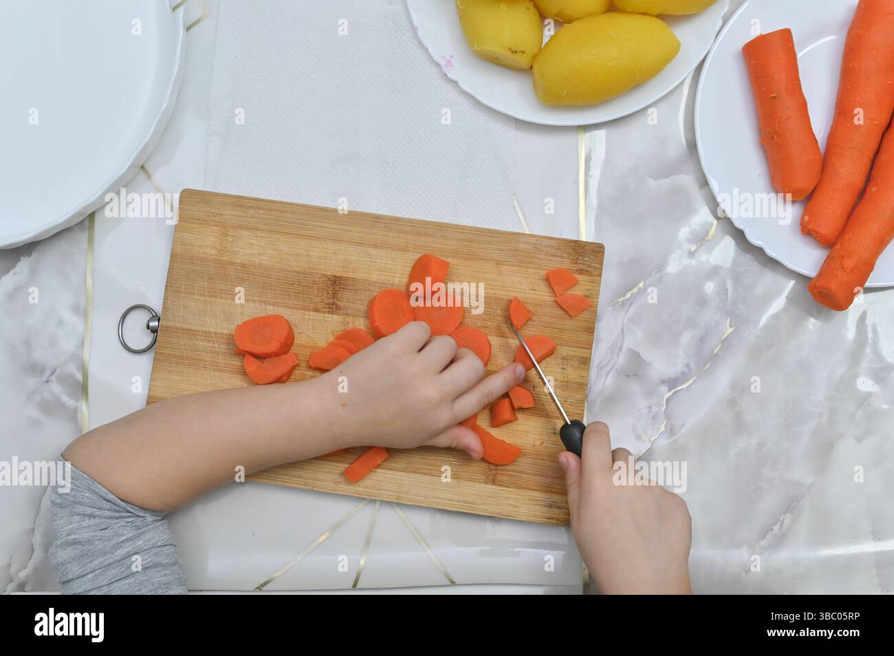 Safety-first cooking lesson: child uses blunt knife to chop steamed ...