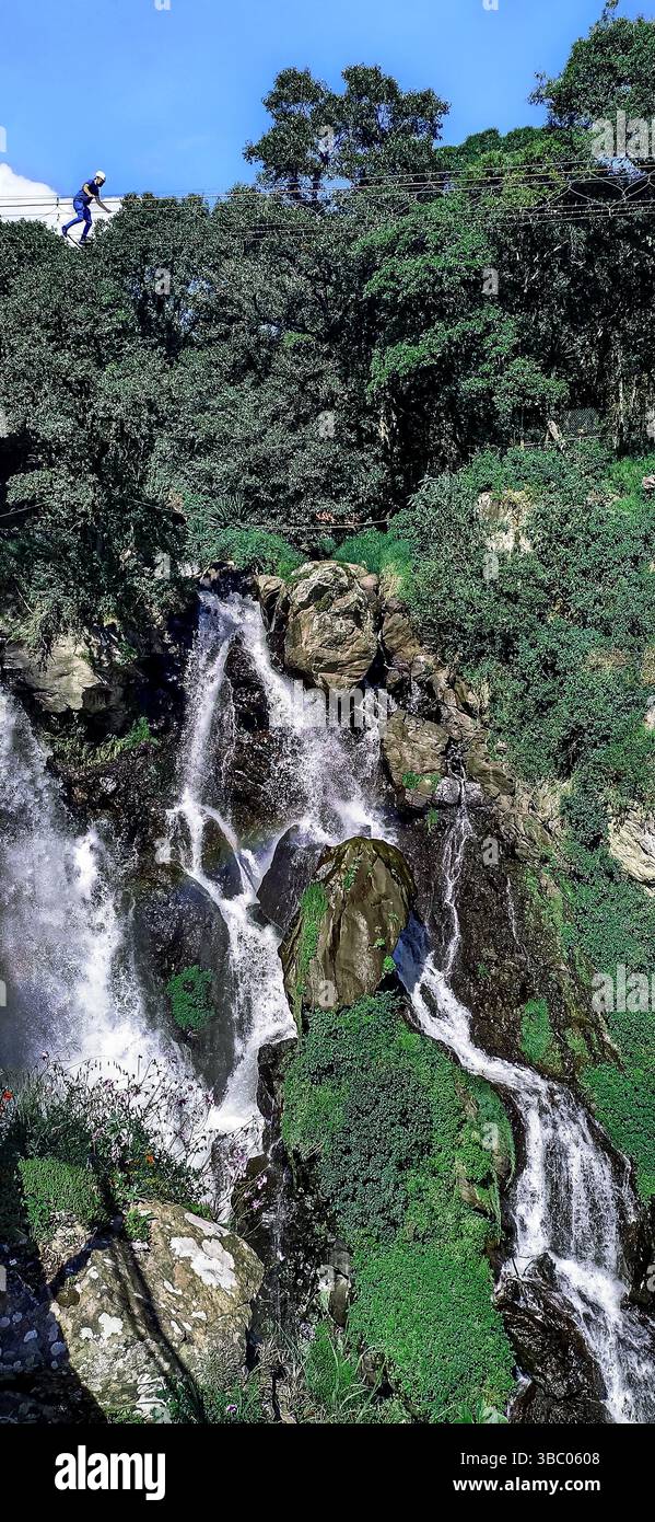 Extreme. Man crossing a rope bridge over a waterfall. Cascada Tuliman ...