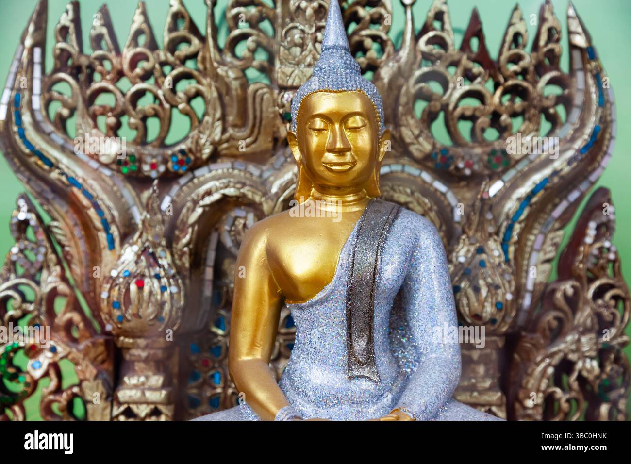 Gilded figure of Buddha on a throne Stock Photo - Alamy