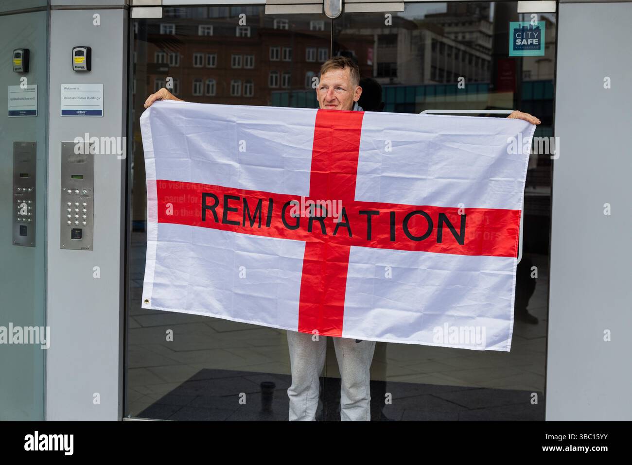 Birmingham, UK. 17 MAY, 2025. Man holds "Remigration" flag as around ...