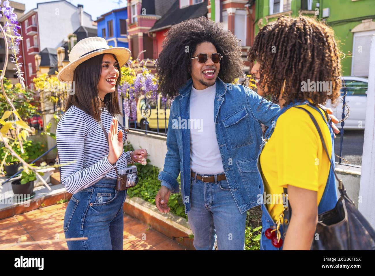 Three happy tourists greeting each other in a residential neighborhood ...