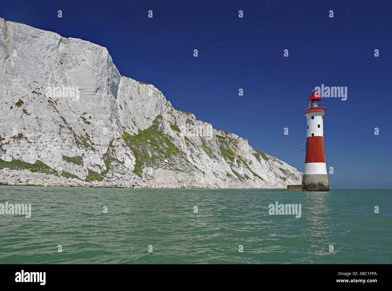 Lighthouse in front of white cliffs at the sea under blue sky, sight ...