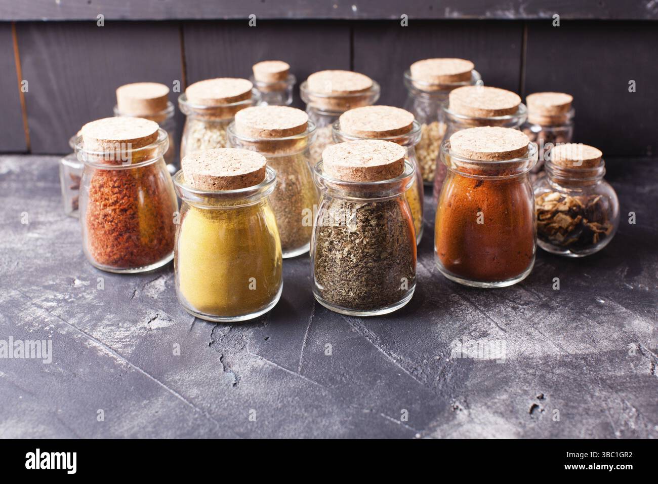 Assortment of dry spices in vintage glass bottles on white background ...