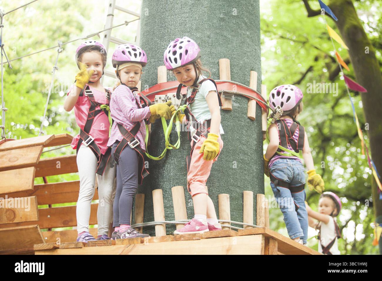 Kids on obstacle course in adventure park in mountain helmet and safety ...