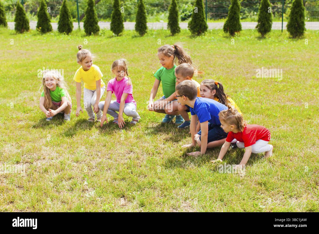 Crouching kids prepared to jump. Sport activities at the school break ...