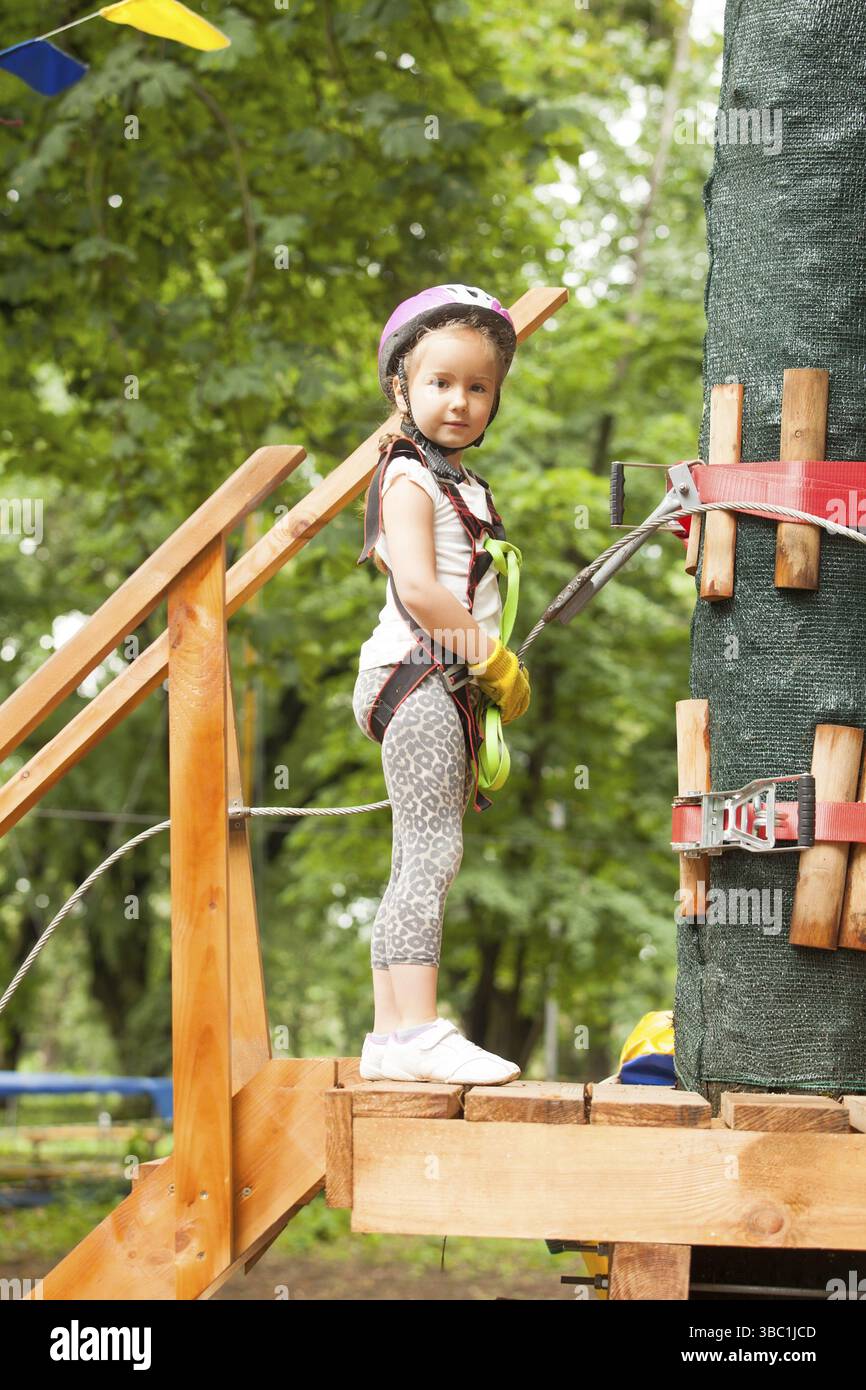 Kids on obstacle course in adventure park in mountain helmet and safety ...
