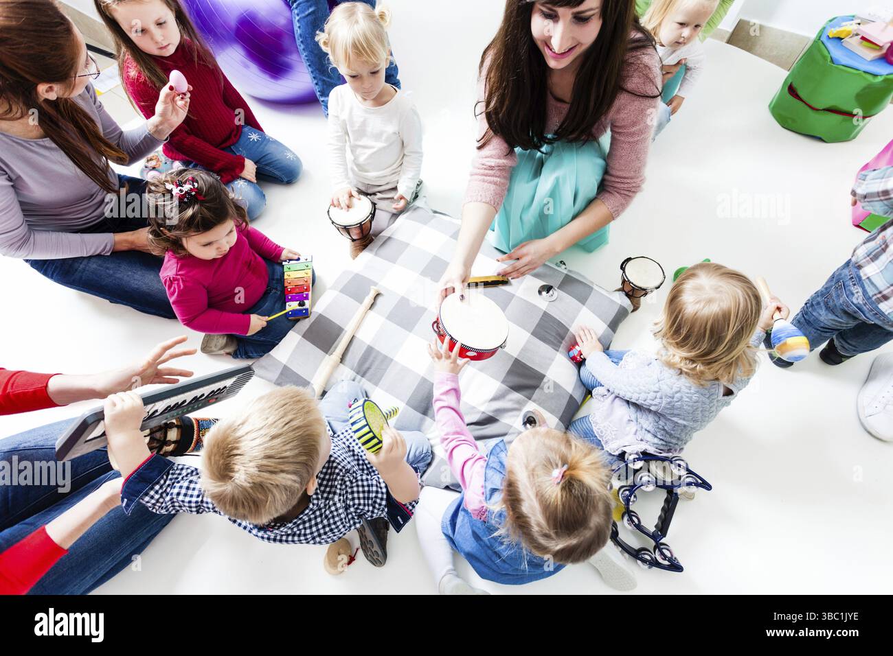 Moms with children at the music lesson in the kindergarten ...