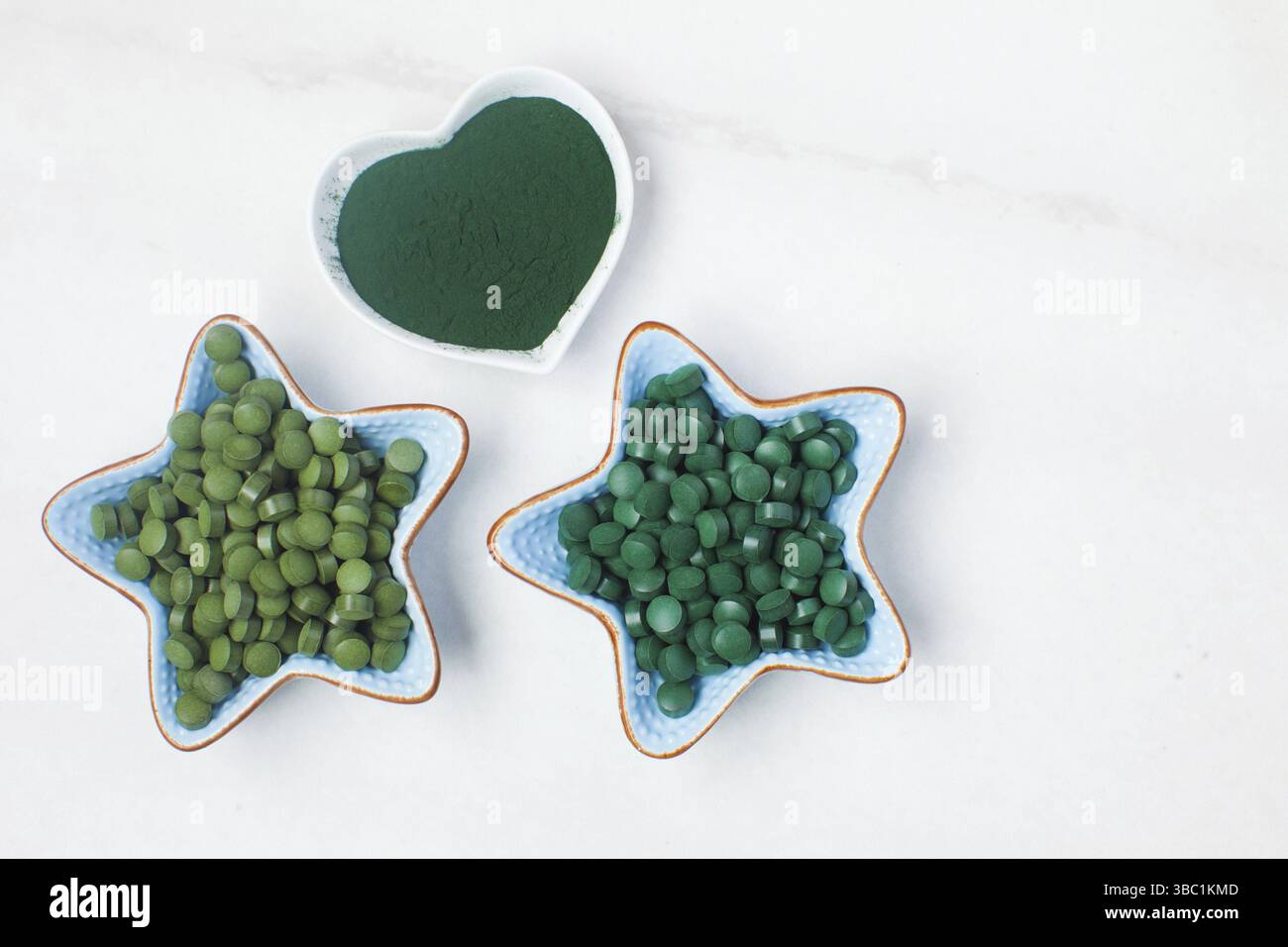 Spirulina algae powder and tablets on white marble background from top ...