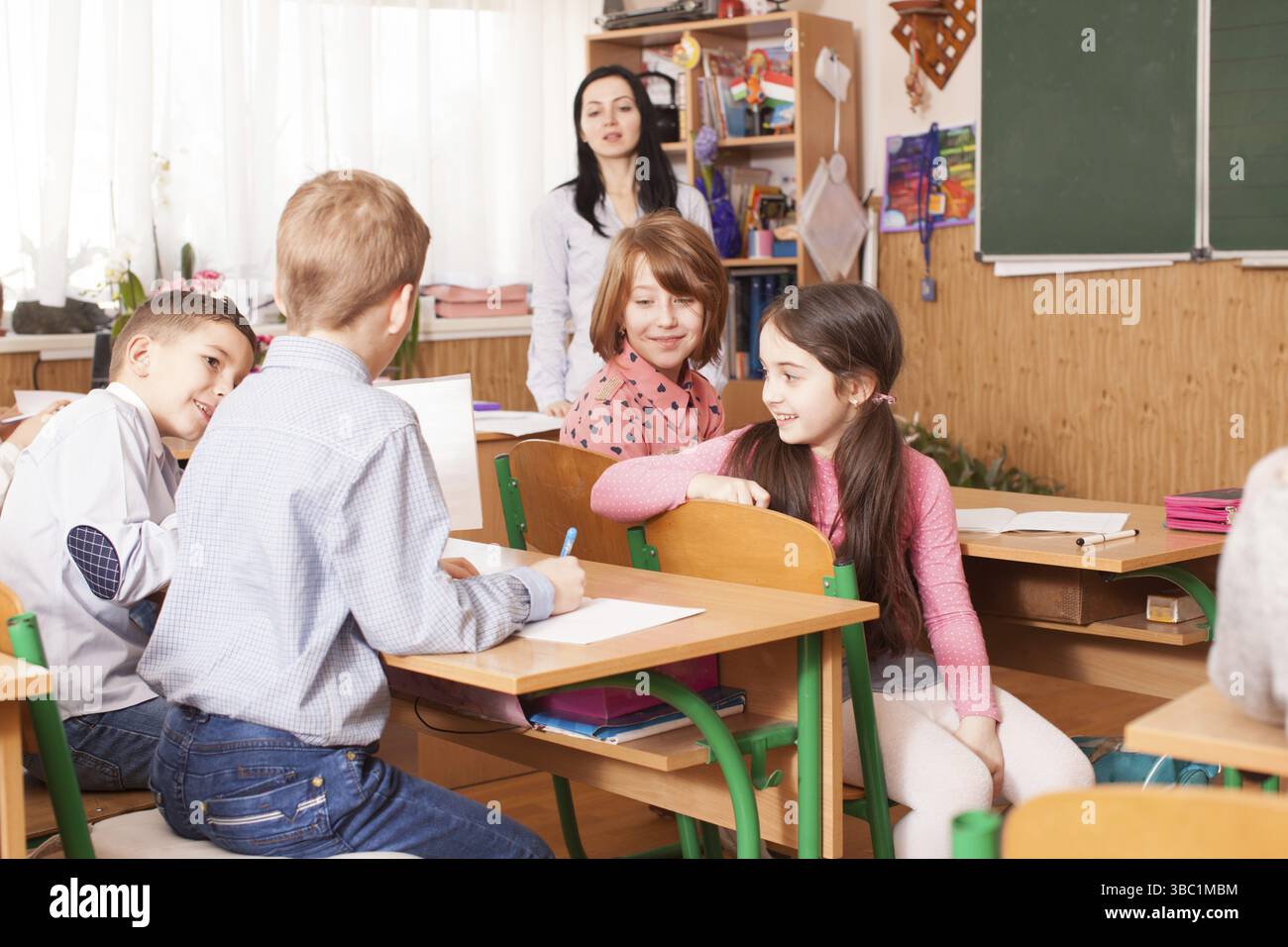 Cute school girl helping her classmate during lesson Stock Photo - Alamy