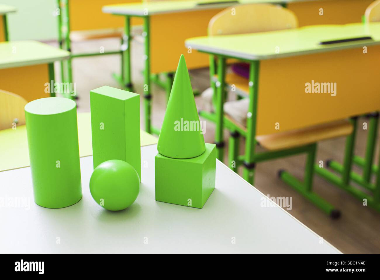 Green geometric figures of different shapes placed on a white surface ...