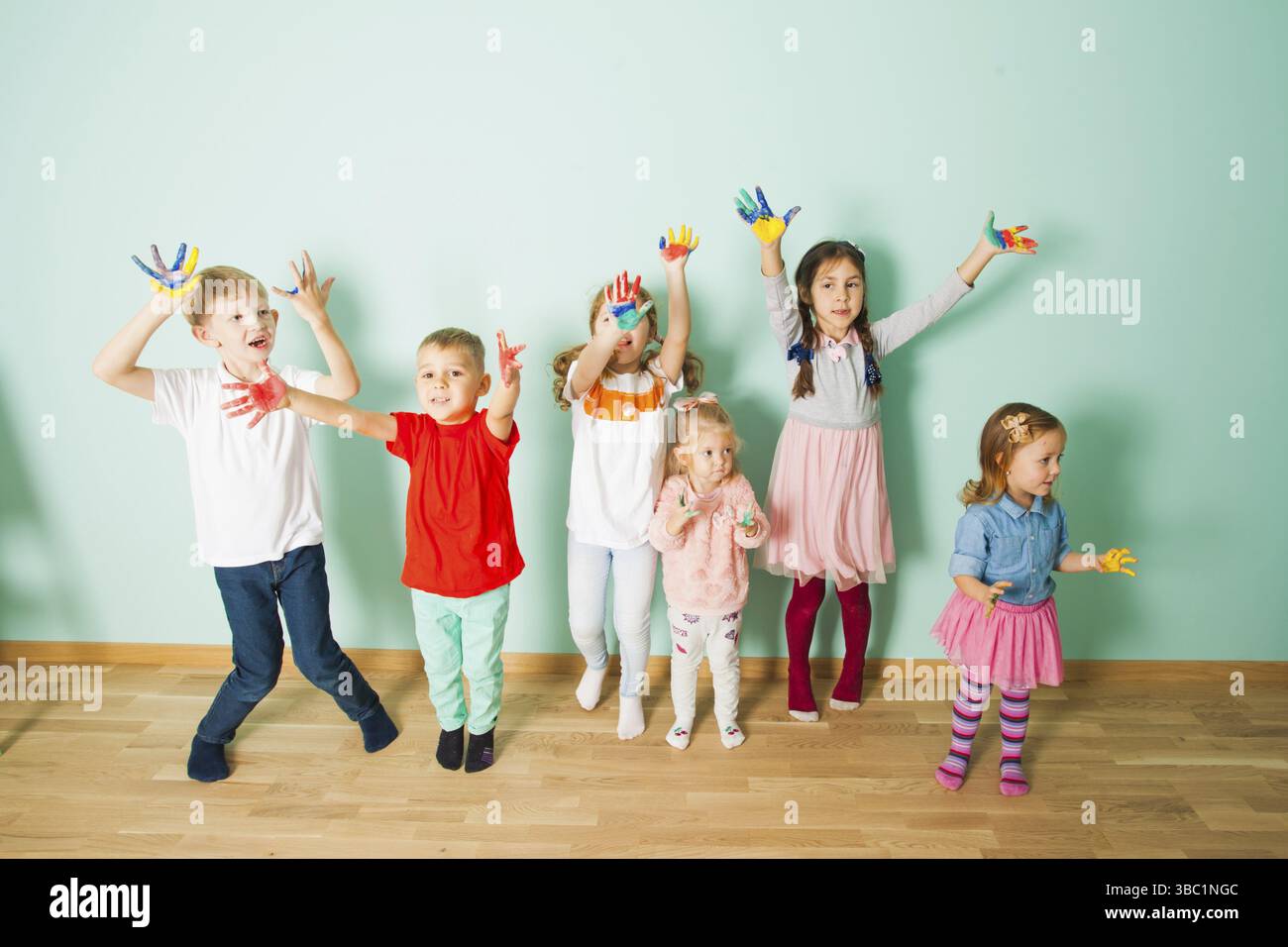 Joyful kids showing their colored hands having fun while creative ...