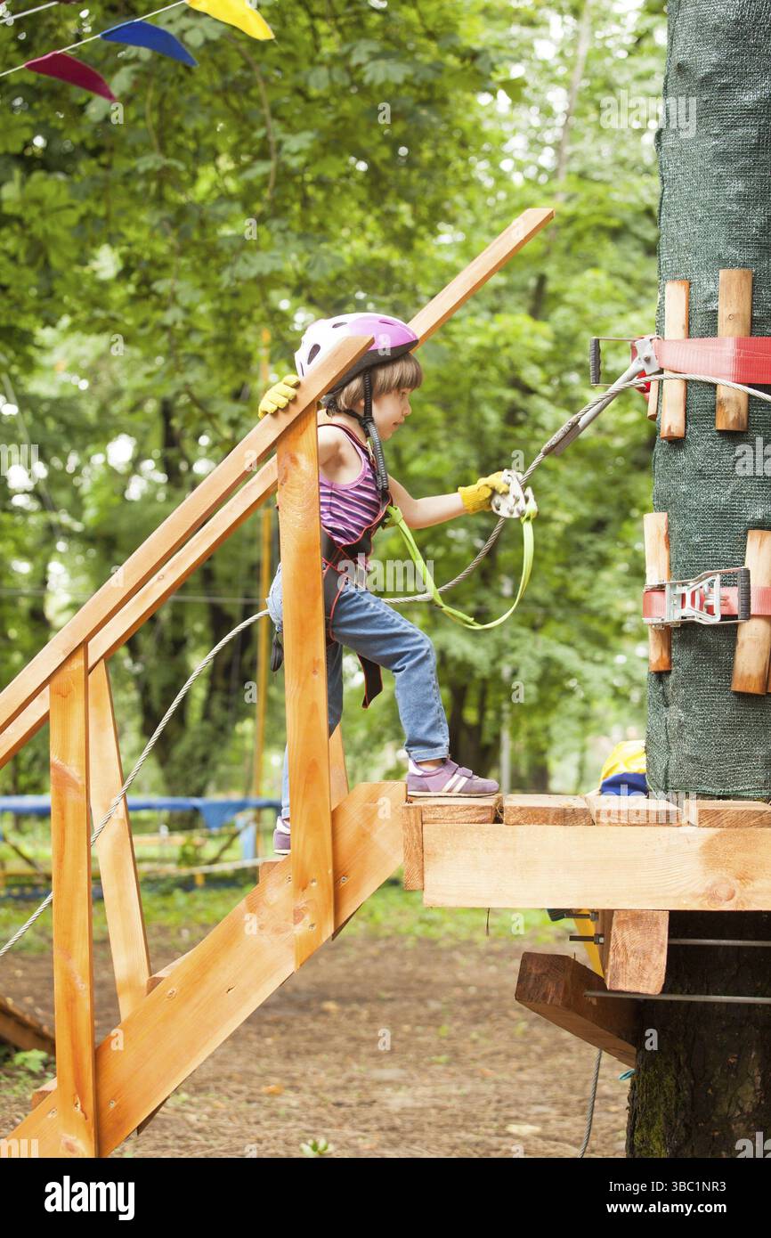 Kids on obstacle course in adventure park in mountain helmet and safety ...