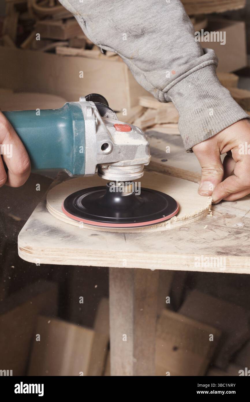 Worker polishing wood table where carpenter hands sanding a wood with ...