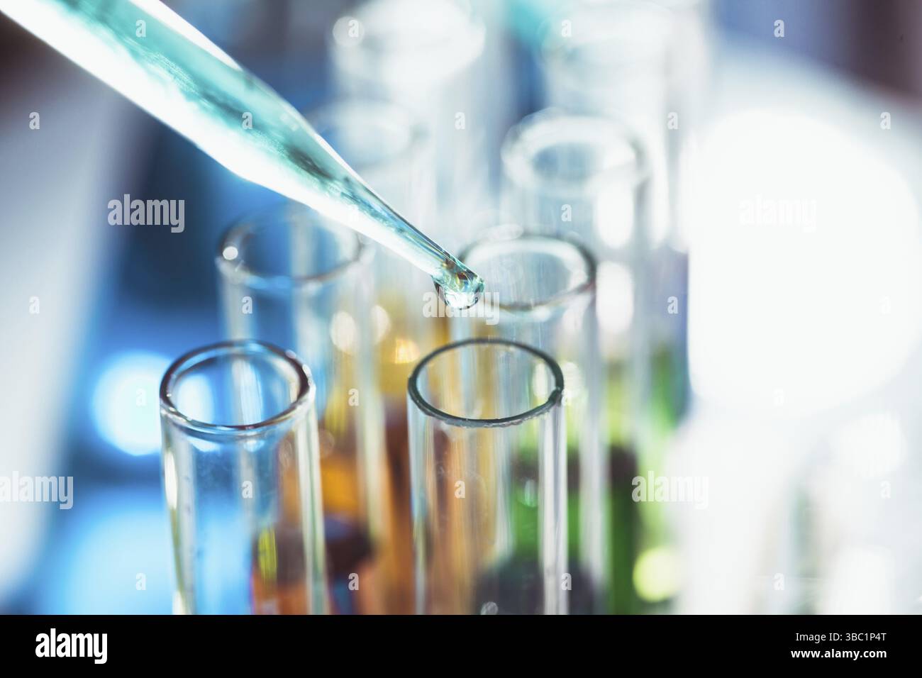 The blue drop from pipette over laboratory tubes Stock Photo - Alamy