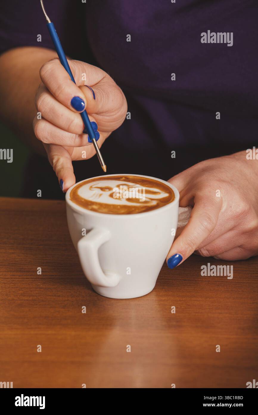 Barista making a cup of latte art coffee with special metal device ...