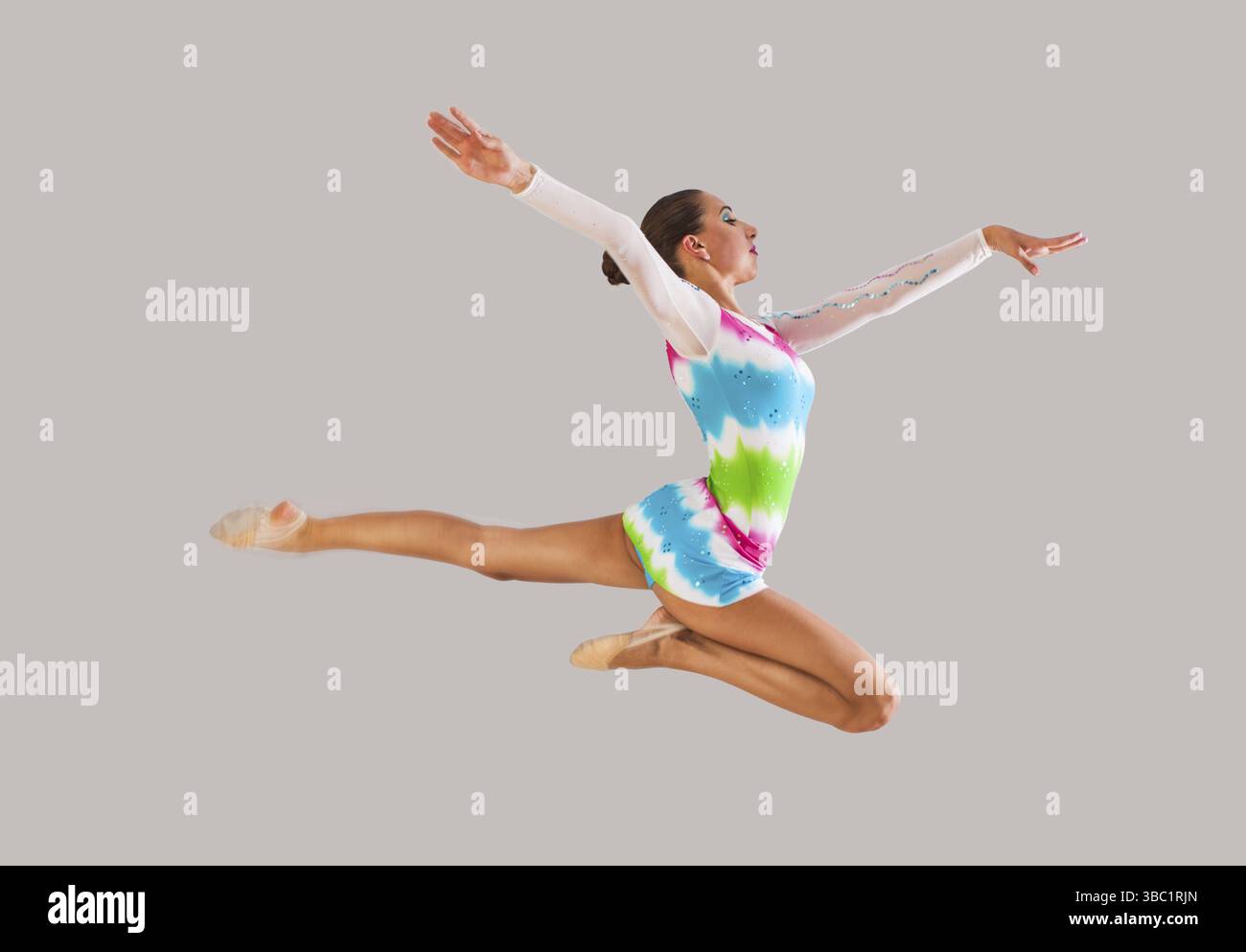 Young slim gymnast jumps sporty figure indroors Stock Photo - Alamy