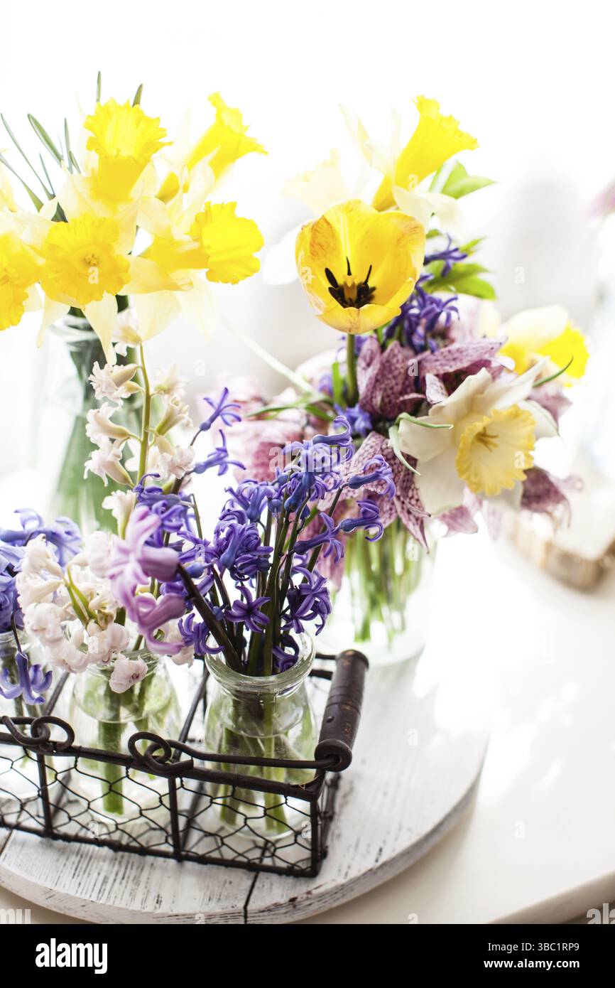 Beautiful vivid spring flowers in vintage glass bottles Stock Photo - Alamy