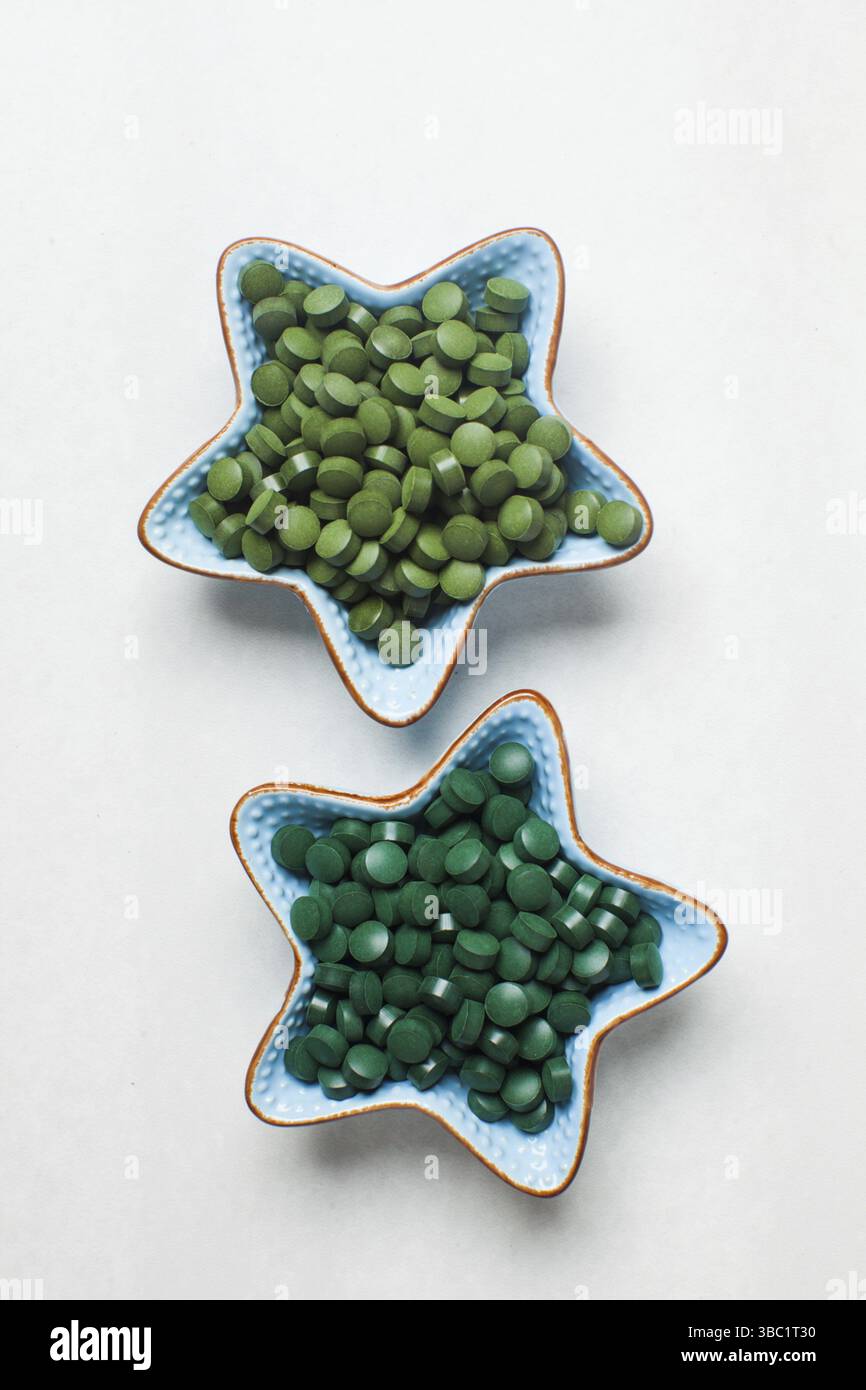 Spirulina algae and chlorella tablets on white marble background from ...