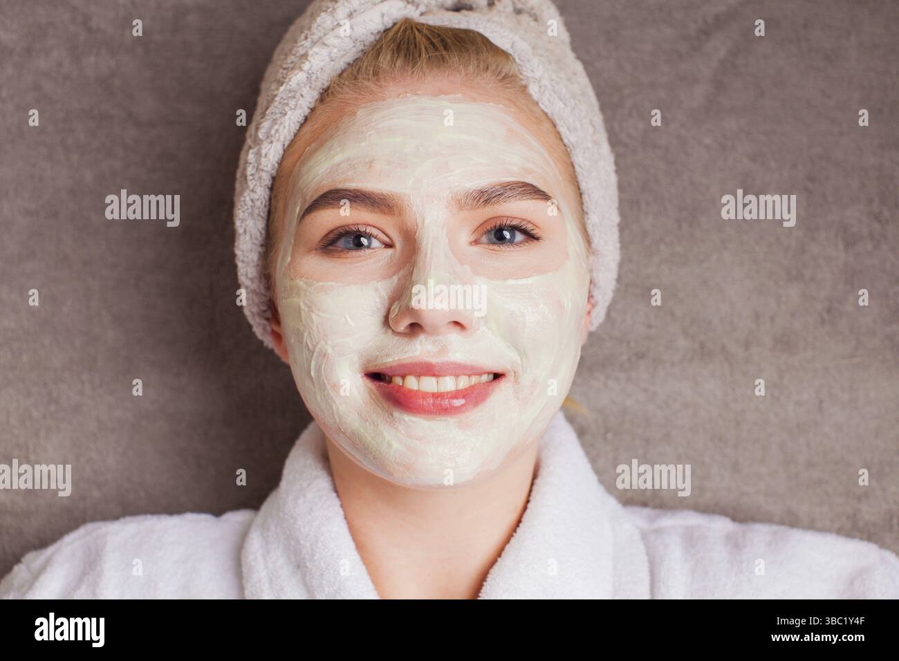 The pretty young woman is lying with a wellness mask on her face and ...