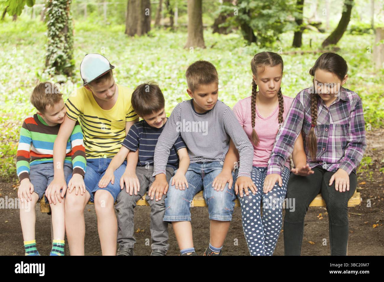 Children sitting together on the bench and play in clapping game Stock ...