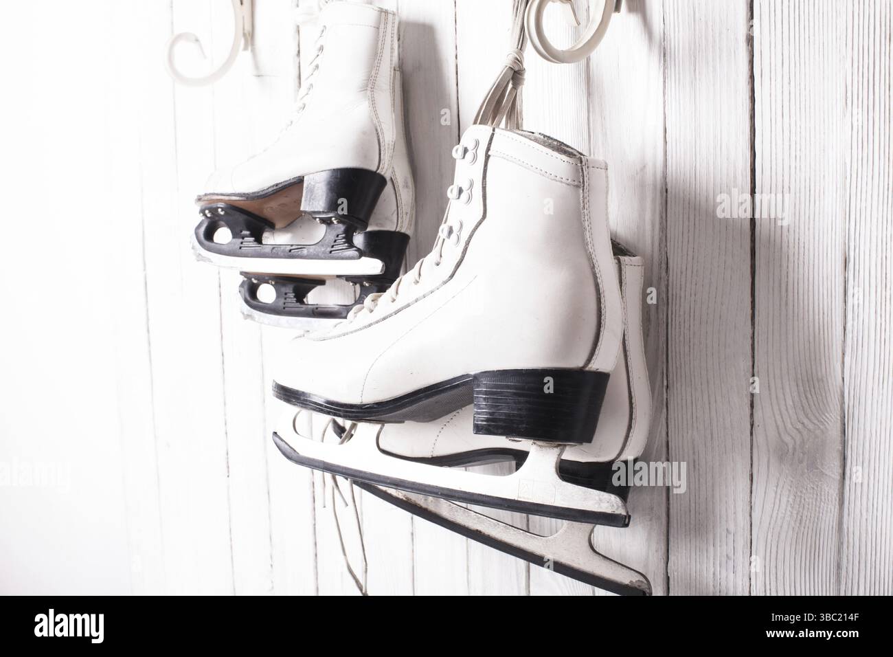 Two pairs of skates hanging on the hook. Family skating concept Stock ...