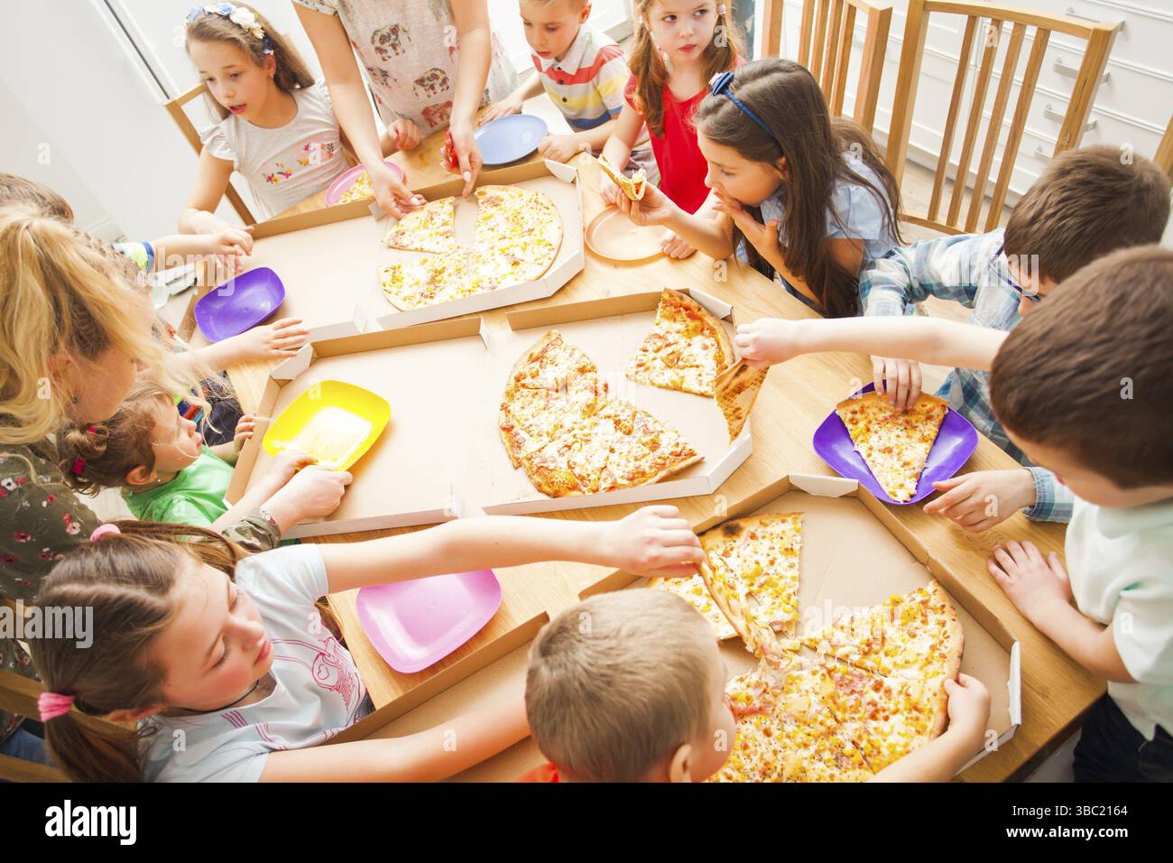 Happy kids eating pizza and having fun together. Birthday party Stock ...