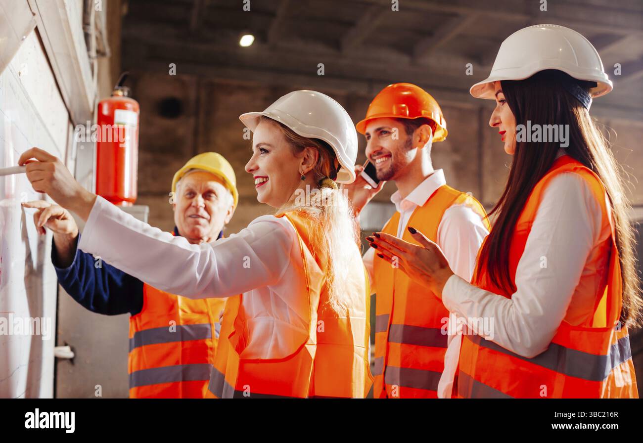 The group of workers stands next by the flip chat and plans work Stock ...