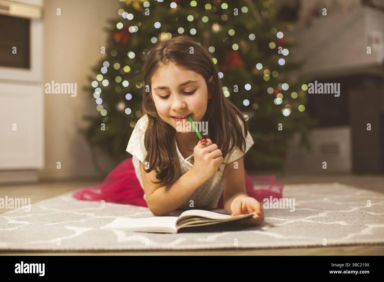 Happy preteen girl writing letter to Santa in decorated room. Beautiful ...