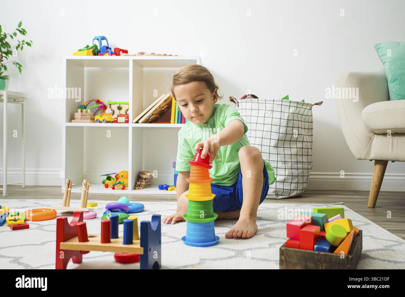 Lonely boy building tower from colorful plastic details. Child playing ...
