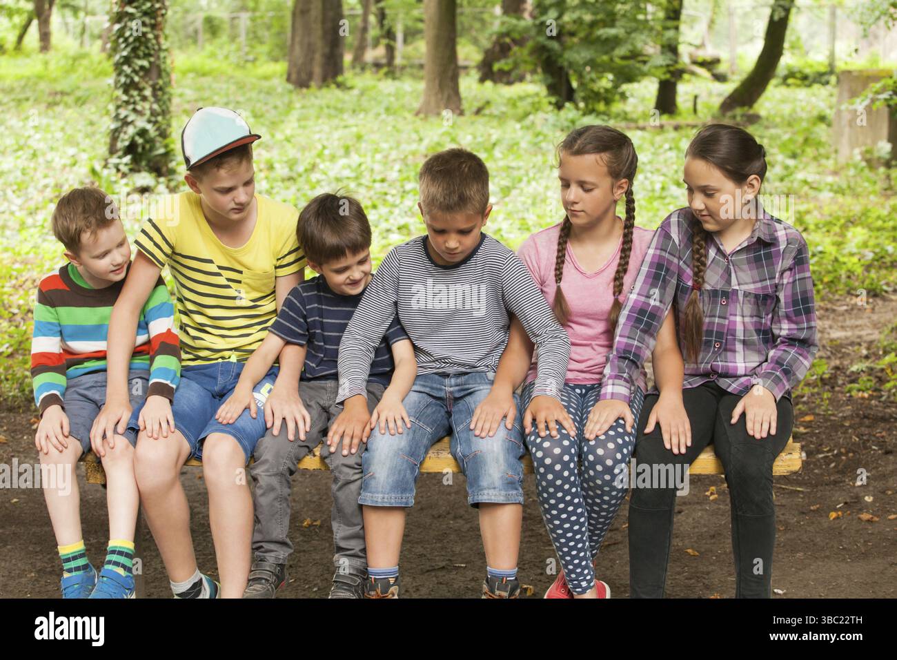 Children sitting together on the bench and play in clapping game Stock ...