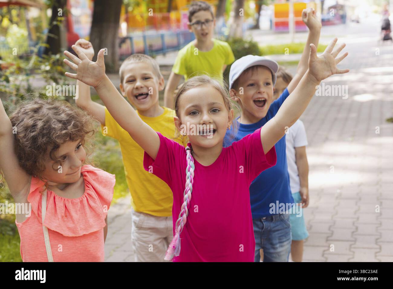Group of preschool children, happily laughing and holding hands up ...