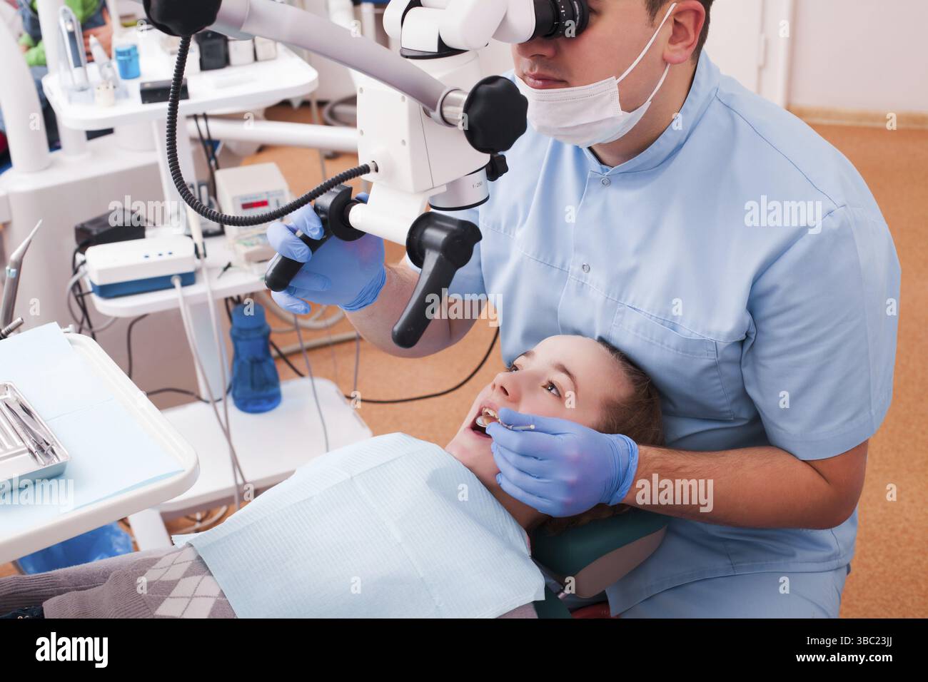 Dentist looking through magnifying glass. He's using microscope for ...