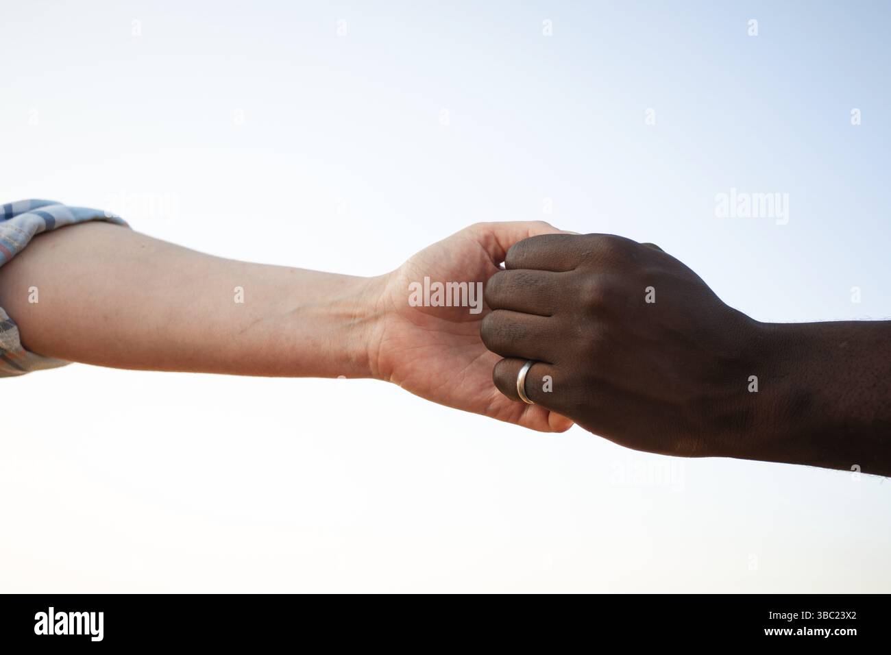 Diverse culture and race couple concept. Two multiracial hands outdoor ...