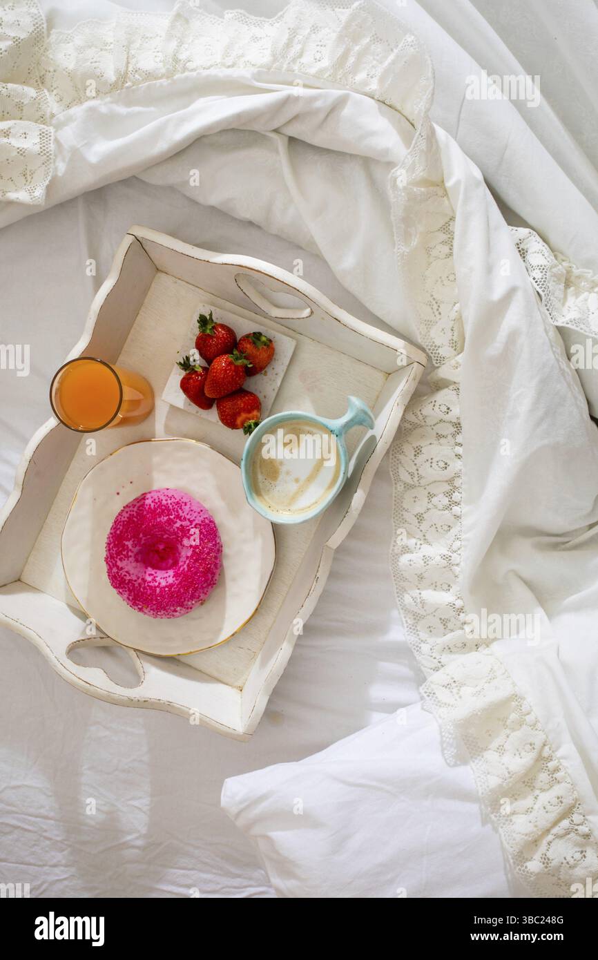 Top view white wooden tray with delicious breakfast, placed on bed with ...