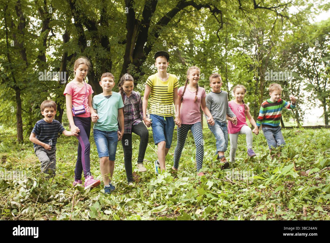Group of happy children running across the lawn in summer Stock Photo ...