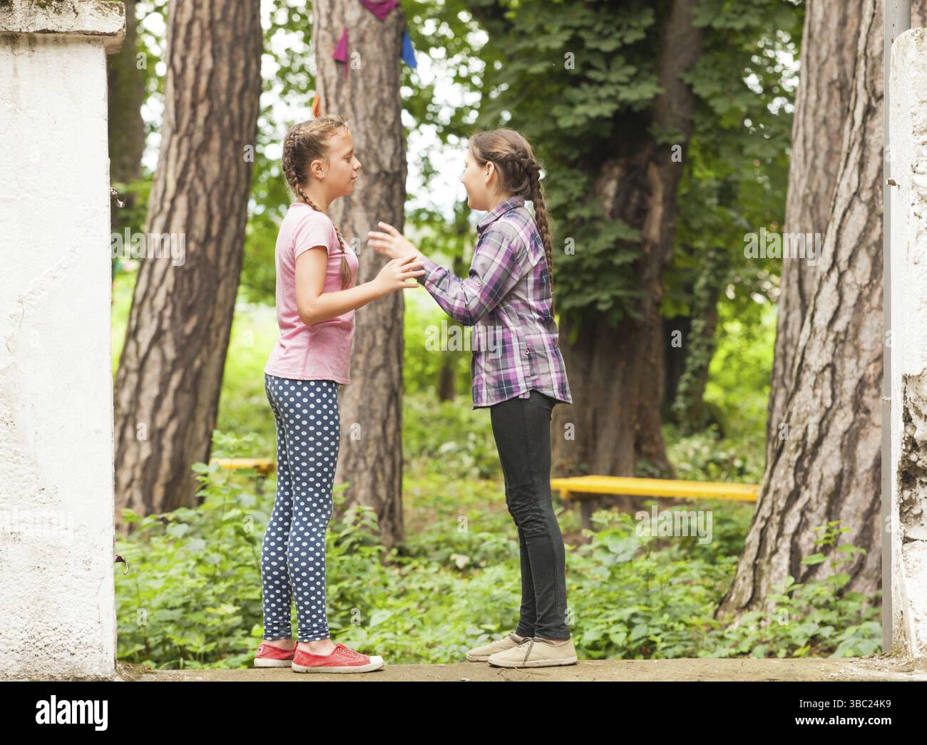 Two girls are playing hands clapping game outdoors, teenagers ...