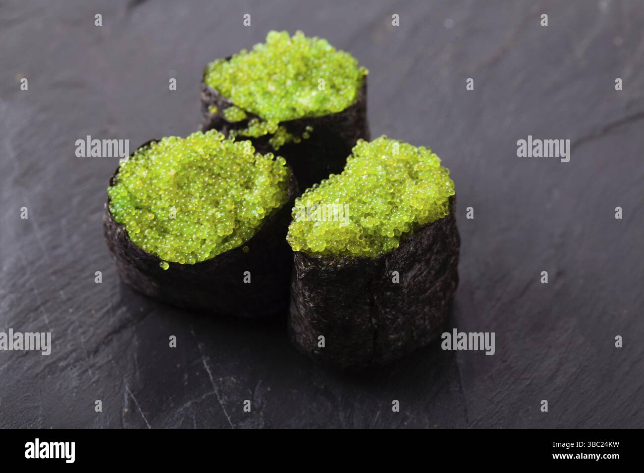 Close-up of Tobiko green nigiri sushi with flying fish roe on a black ...