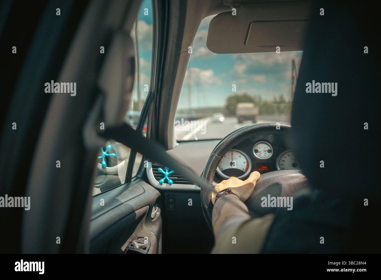 View from the back seat of the driver's hand and the steering wheel ...