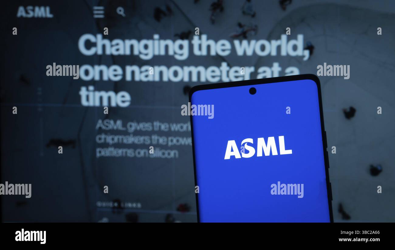 ASML logo on phone and blurred AI chip manufacturing int he factory ...