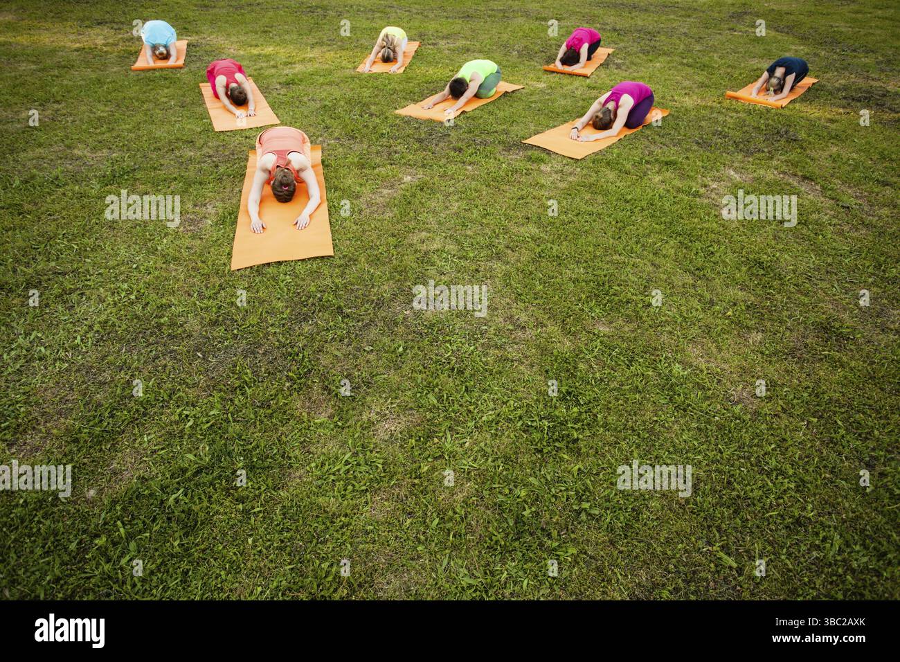 Group of girls relaxing and doing childs pose in yoga on a nature Stock ...