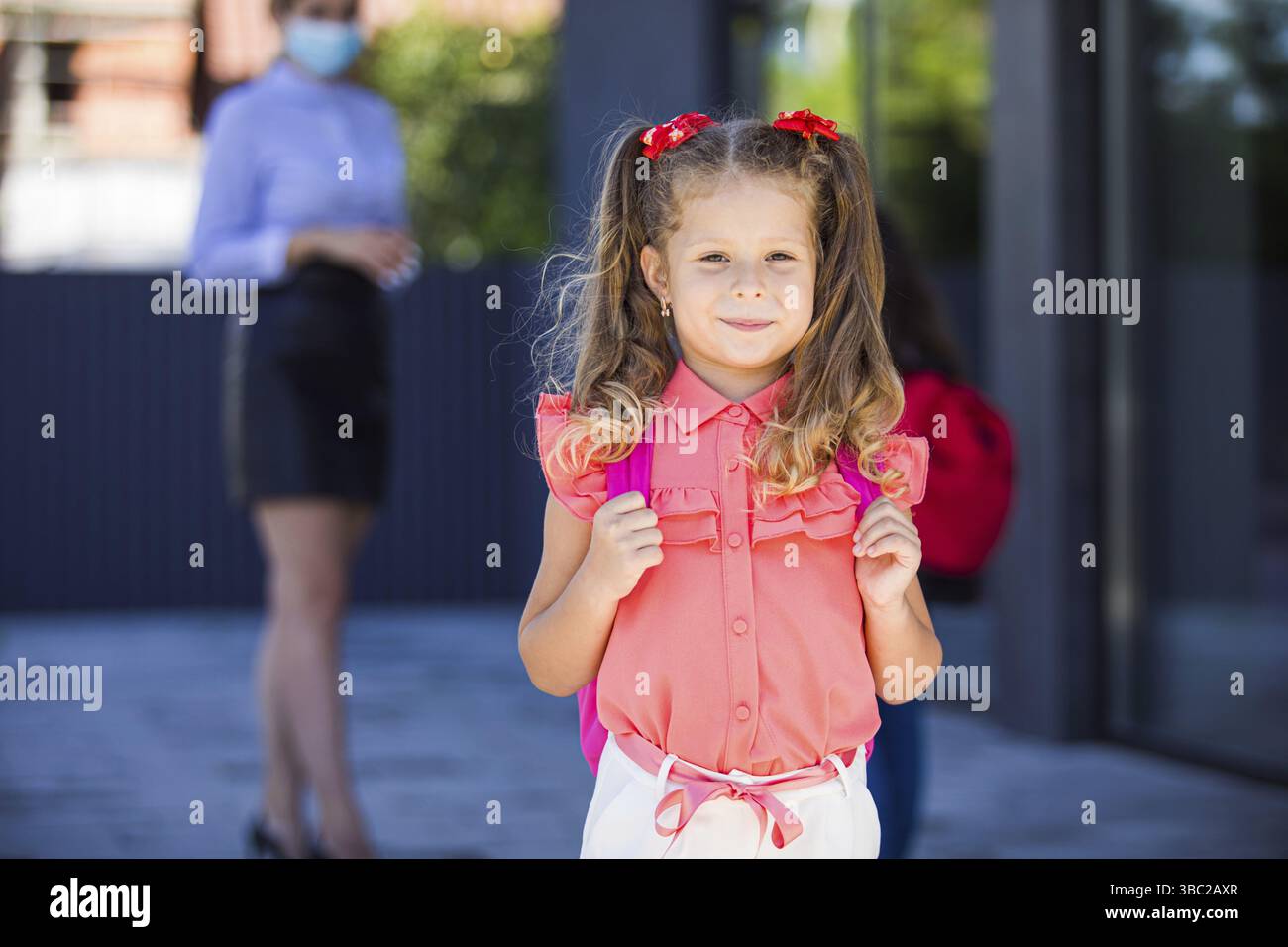 Pretty elementary schoolgirl with two tails wears pink blouse, holding ...