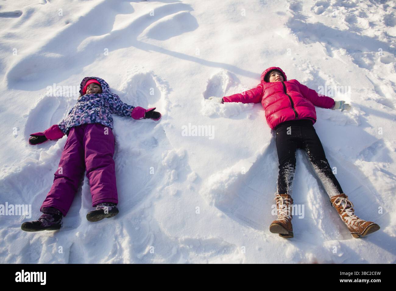 Two children make snow angels hi-res stock photography and images - Alamy