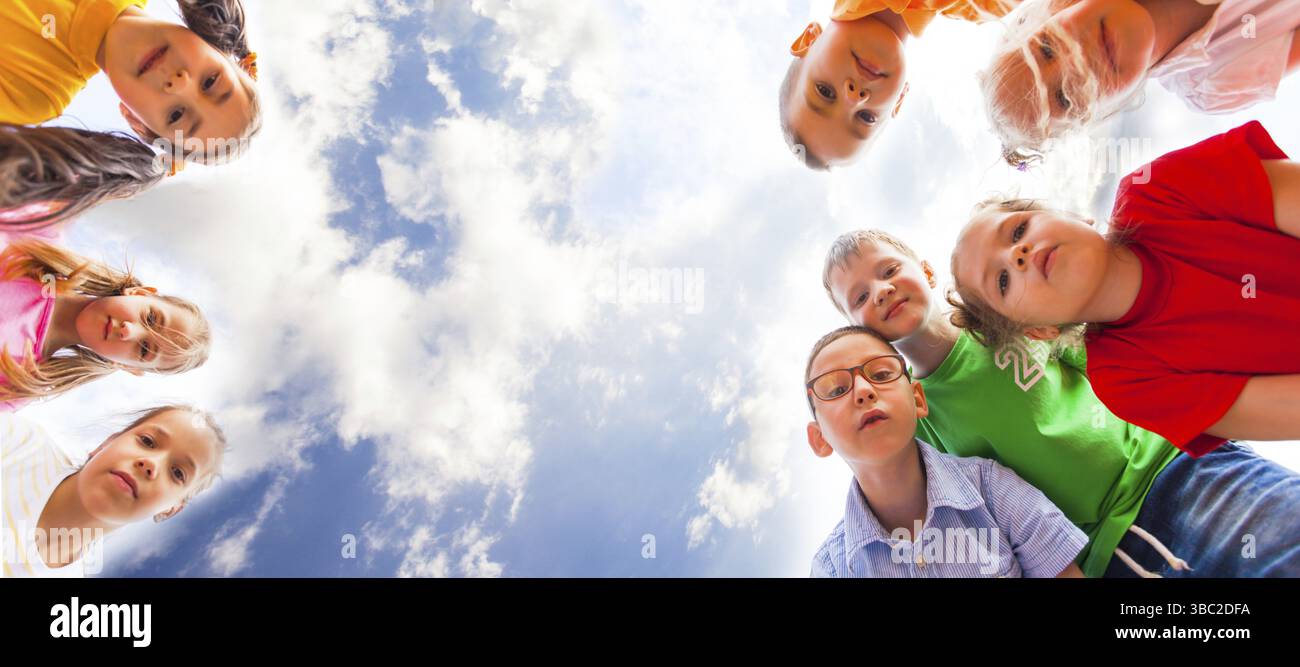 Five happy kids standing leaning upon the camera looking at it. Lovely ...