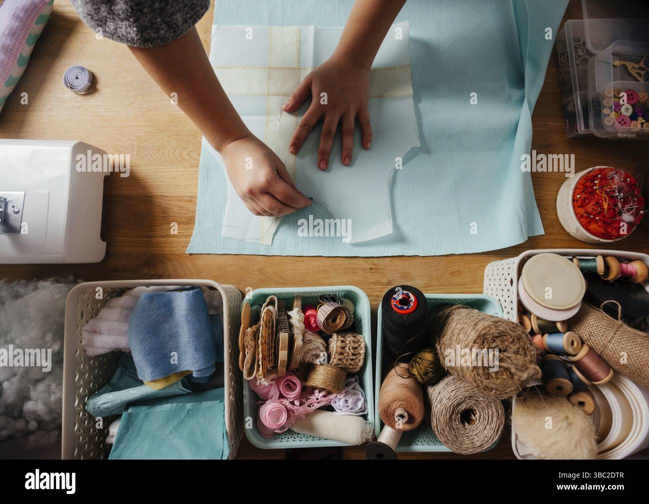 Top view woman drawing along the contour of children clothes paper ...