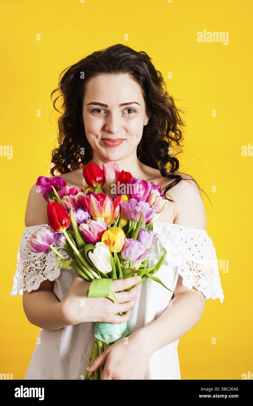 The pretty girl model poses for a camera with tulips Stock Photo - Alamy